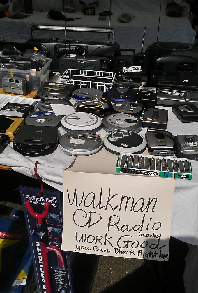 "Walkman CD Radio cassette WORK GOOD"—a time machine disguised as a table of electronics that once seemed impossibly futuristic.