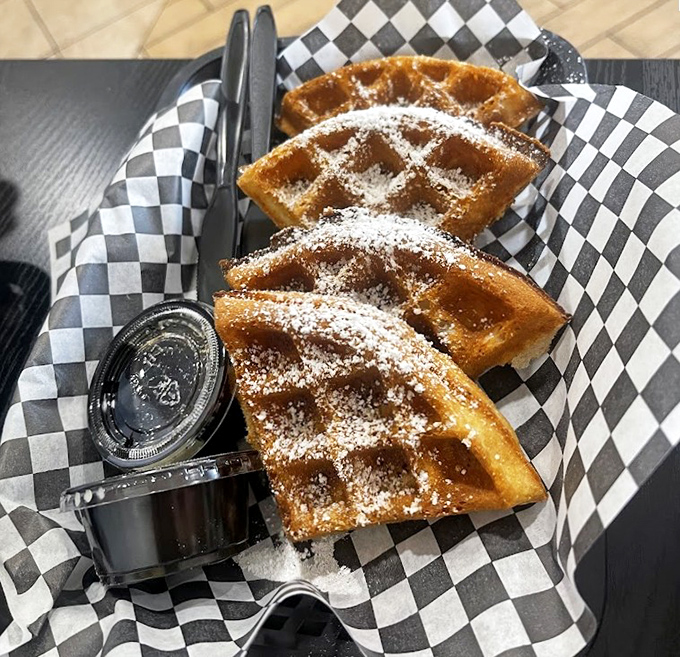 Waffles dusted with powdered sugar that would make Belgian grandmothers nod in approval. The perfect sweet counterpoint to all that savory spice.
