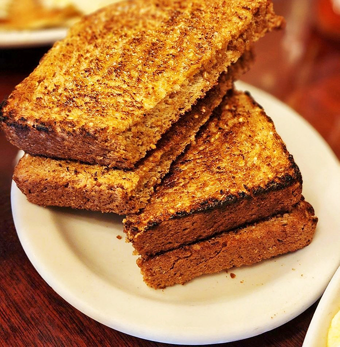 Whole wheat toast that's actually worth ordering—golden-brown slices that have been transformed from health food into something decadently satisfying.