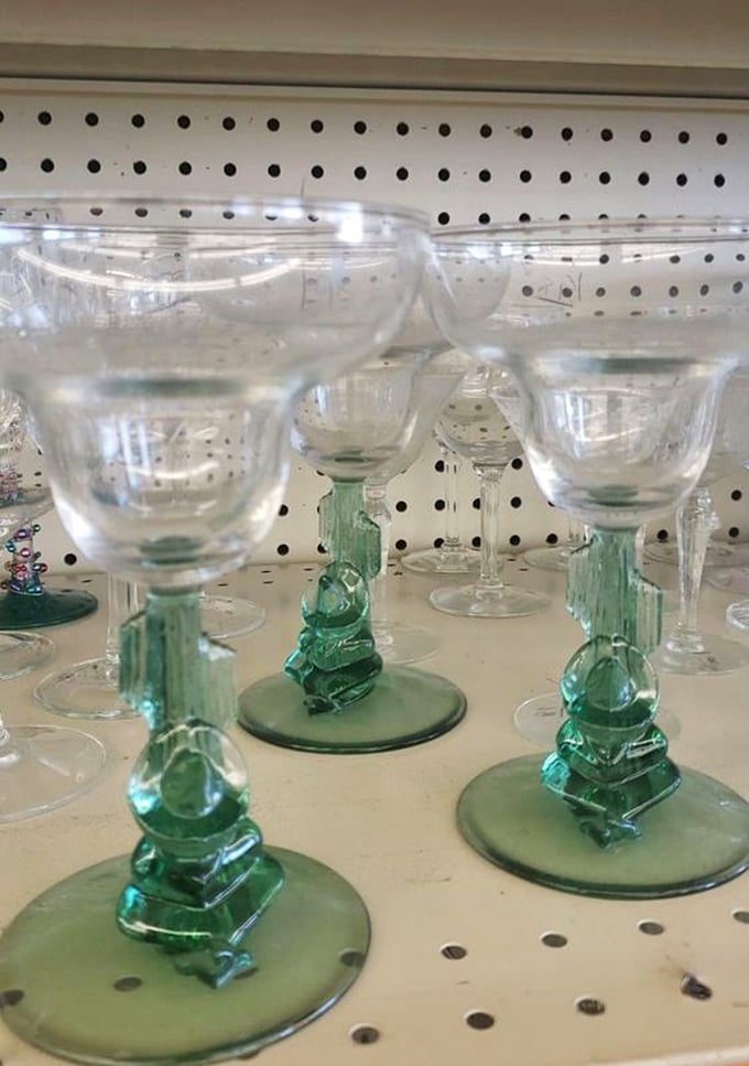 Vintage glassware with emerald stems stands at attention like elegant soldiers. Someone's forgotten wedding gift becomes your dinner party conversation piece.