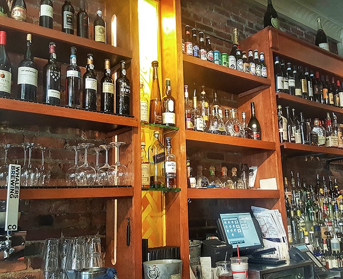 The bar shelves glow like an amber library of spirits, each bottle promising its own unique pairing with the ocean's finest offerings.