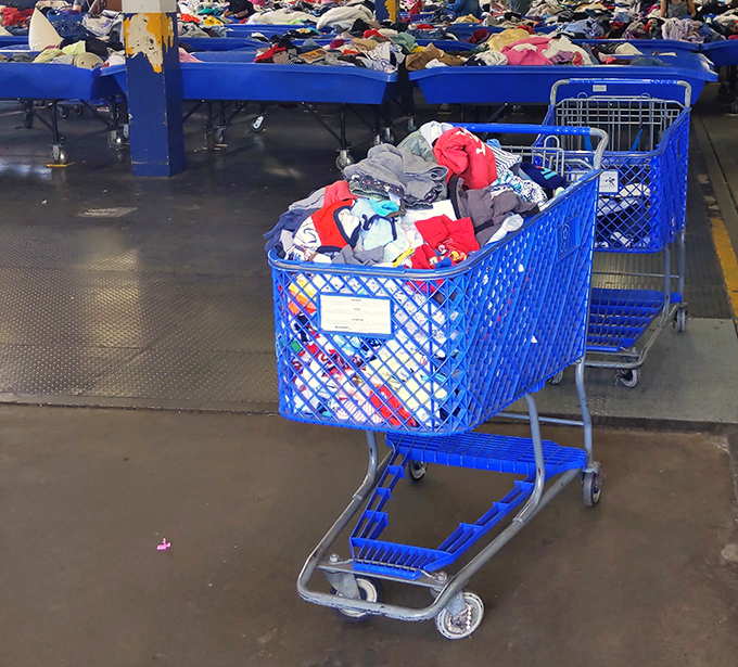 A shopping cart overflowing with secondhand clothes, ready for thrifters to explore and find their next favorite piece.