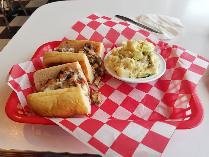 When a cheesesteak comes served on that classic red-checkered paper, you know you're in for the real deal—no pretension, just delicious satisfaction.