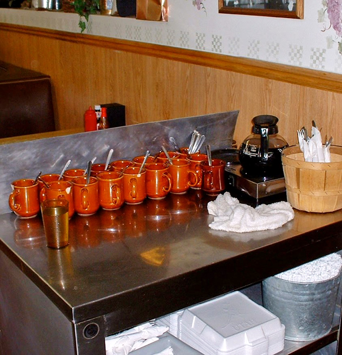 The coffee station: where morning miracles happen one orange mug at a time. Liquid optimism served with military precision.