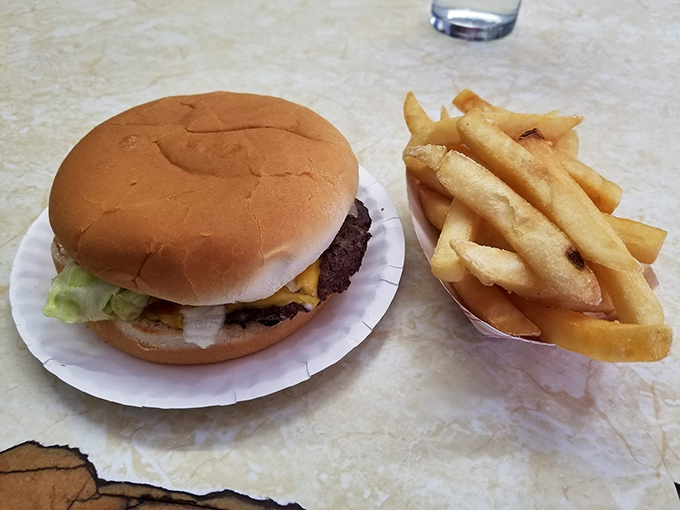 Simple perfection on a white plate: a burger that knows what it is, fries that don't need reinvention, and coleslaw that completes the holy trinity.