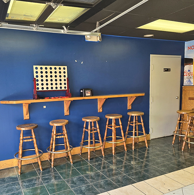 Blue walls and wooden stools create the perfect perch for pizza contemplation. That Connect Four game has probably settled more family disputes than therapy.