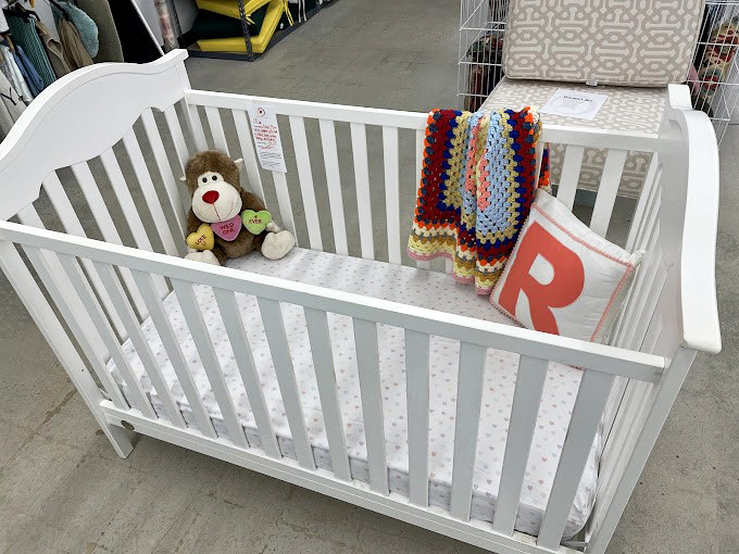 A pristine crib complete with teddy bear roommate. Perfect for parents who understand babies outgrow everything faster than you can say "college fund."