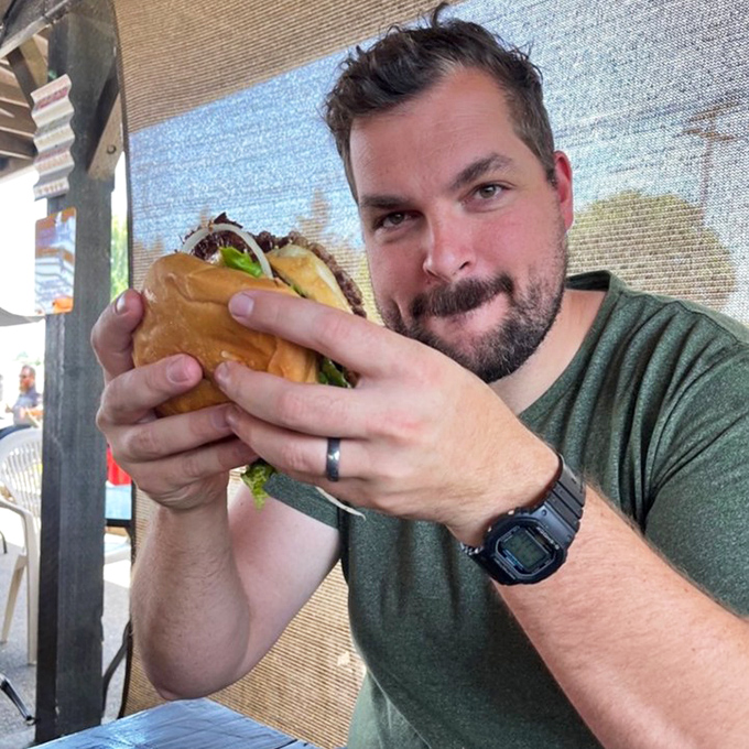 That moment when you realize your burger might be bigger than your face &ndash; pure joy captured in mid-bite.