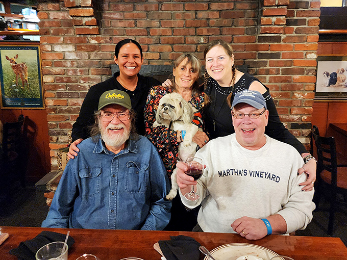 Happy diners proving that good food creates instant friendships, even with strangers at the next table.