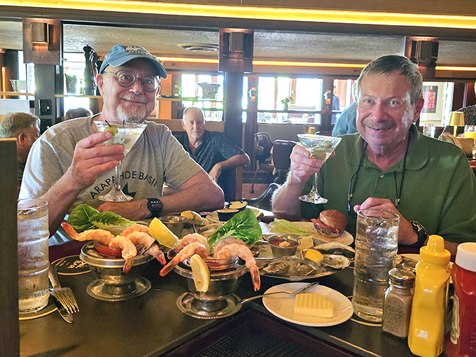Happy diners toasting life with martinis and seafood towers&mdash;proof that the best memories are made between cocktails and dessert.