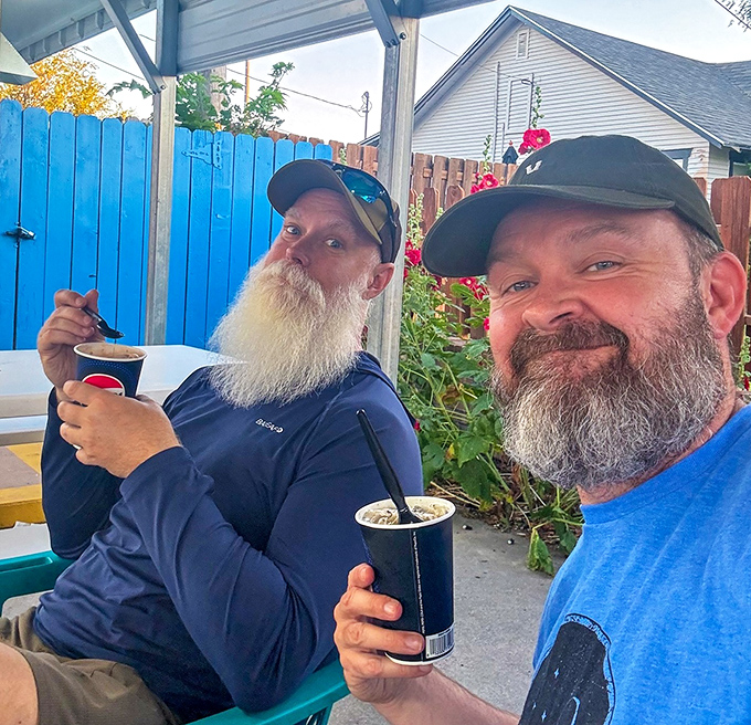 Two bearded gentlemen enjoying the simple pleasure of frozen treats, proving that ice cream happiness knows no age limit.