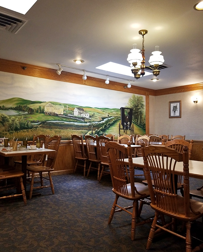 The pastoral mural transforms ordinary dining into a countryside escape, no bug spray or sunscreen required.