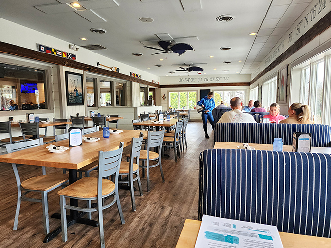 Comfortable booths with nautical blue stripes create that relaxed waterside vibe without trying too hard to impress anyone.