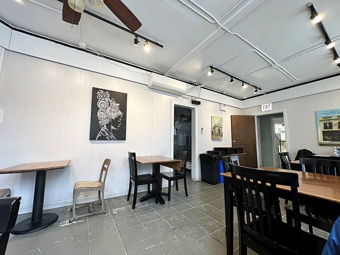 Clean lines, local art, and tables waiting for stories. The minimalist dining area serves as the perfect canvas for the colorful conversations that happen here.