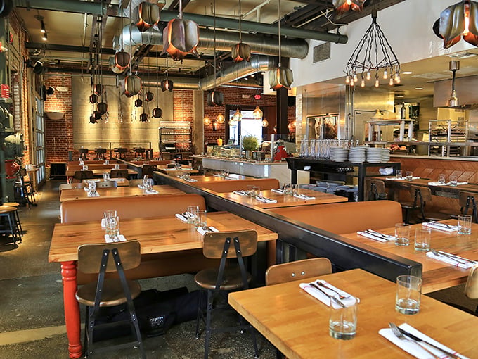 Wooden tables, leather booths, and copper pendant lights create a dining room where industrial meets intimate&mdash;like a hug in warehouse form.