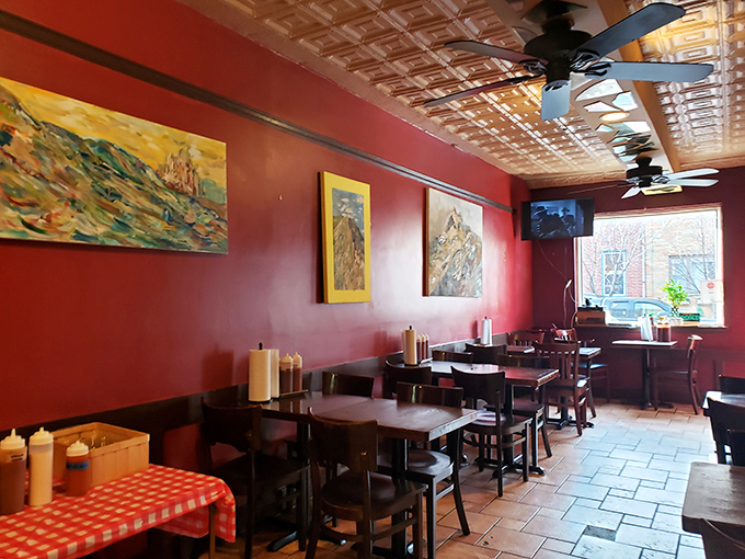 The dining area's pressed tin ceiling and vibrant artwork create a cozy atmosphere where strangers become friends over shared barbecue passion.
