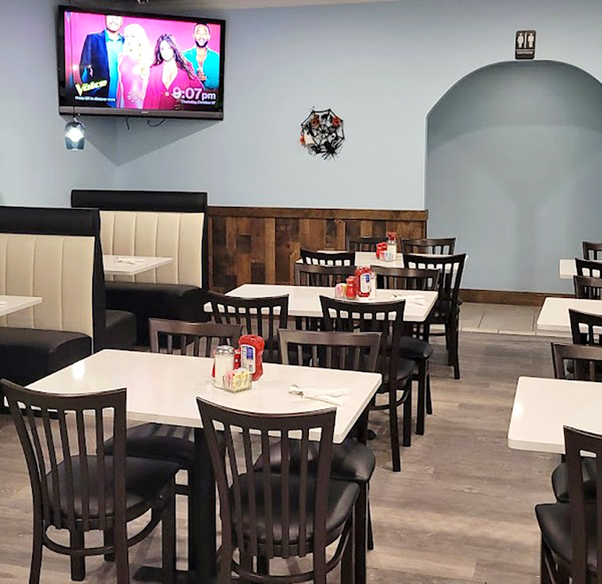 The modern diner aesthetic in full display. Light blue walls, rustic wood accents, and comfortable booths create the perfect backdrop for memorable meals.