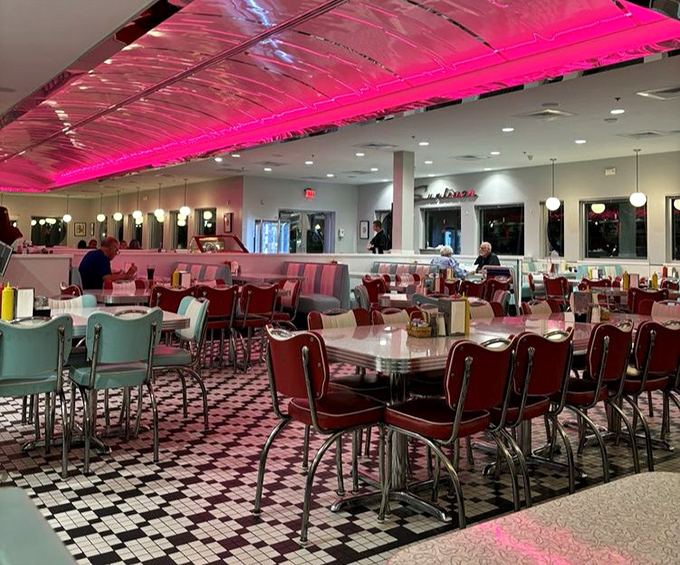 Pink neon bathes diners in a rosy glow as they feast among checkerboard floors and chrome accents. Even Edward Hopper would approve of this scene.