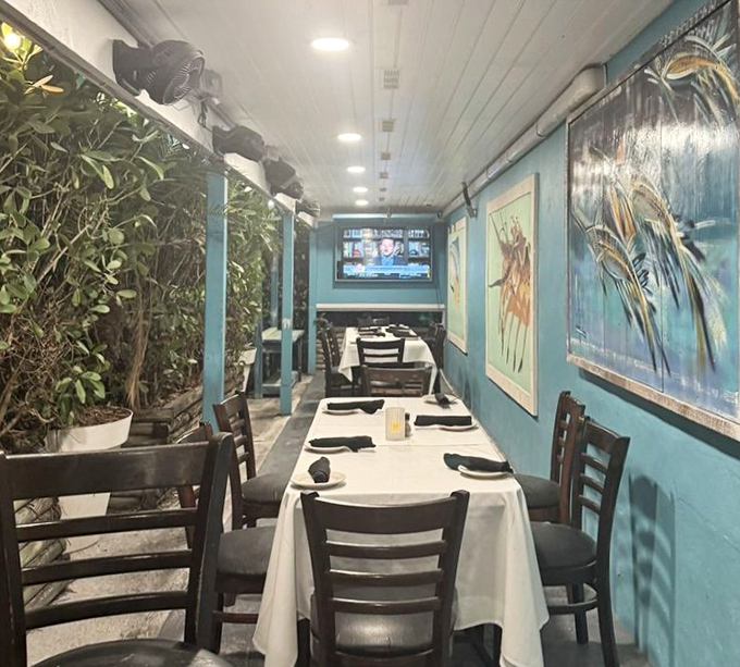 The narrow dining area feels like dining in a stylish aquarium, with blue walls and marine artwork creating an underwater escape.