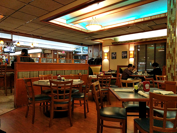 Booths designed for lingering conversations and tables for gathering friends. The warm lighting says, "Stay awhile, your diet starts tomorrow."