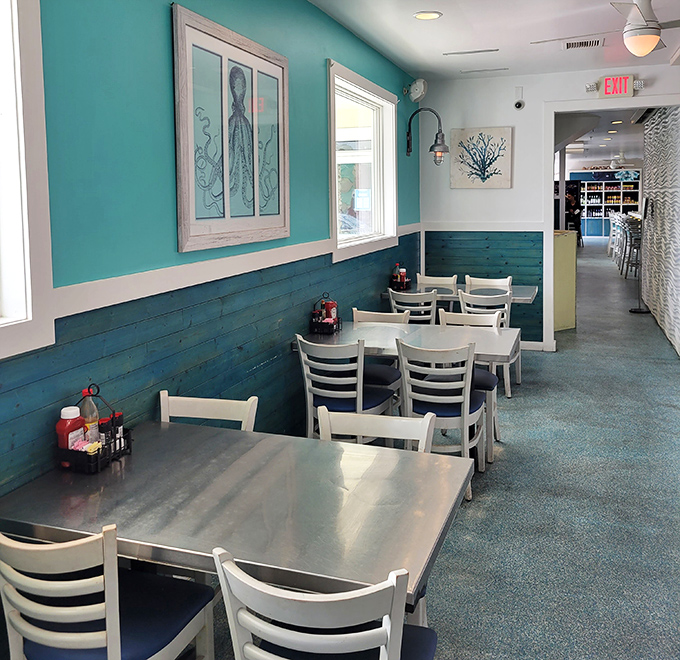 Turquoise walls, blue wainscoting, and white chairs create the quintessential coastal dining room. Even empty, it promises good times and better meals ahead.