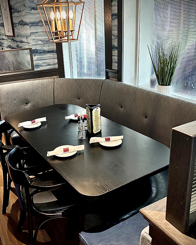 This curved booth isn't just seating&mdash;it's a front-row ticket to the seafood show, complete with elegant lighting and ocean-inspired wallpaper setting the maritime mood.