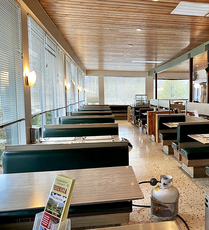 Empty booths waiting for the breakfast rush like actors before curtain call, with wooden ceilings that whisper tales of decades past.