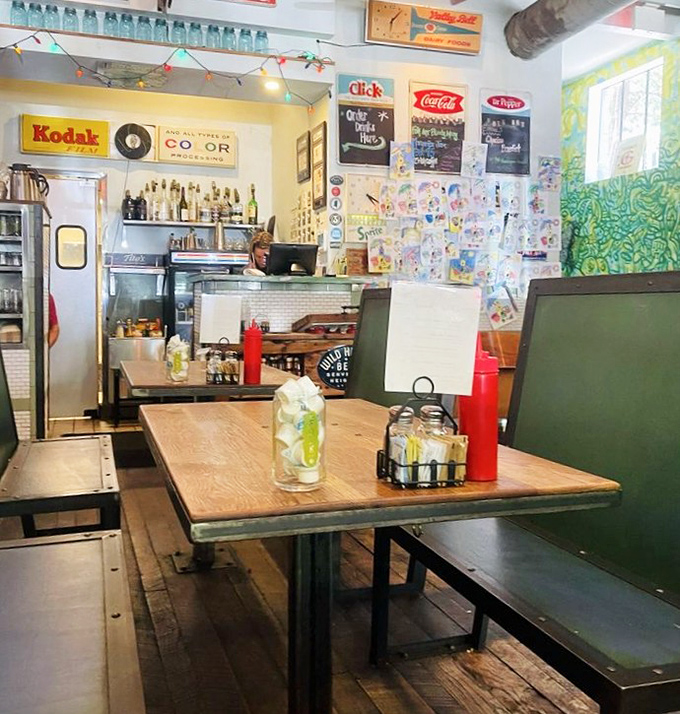 Vintage Kodak signs and colorful walls create a nostalgic backdrop for wooden tables where memories are made between bites of Southern comfort.
