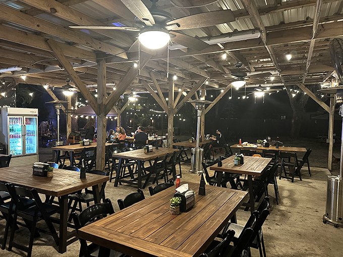 As night falls, the string lights transform this wooden pavilion into a magical dining oasis where memories are made between bites.