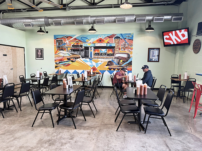 The dining area's colorful mural and industrial ceiling create a space where you can focus on what matters: the serious business of enjoying exceptional barbecue.