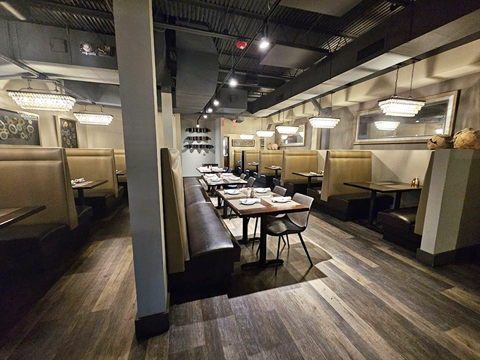 Cream-colored booths create intimate dining pockets where conversations flow as smoothly as the wine being poured.