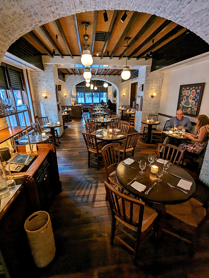 Exposed brick arches and wooden beams create a dining room that feels like you've discovered a secret culinary cave of wonders.