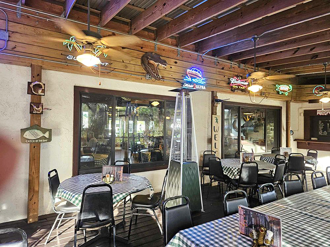 The dining area balances rustic charm with Florida kitsch. Neon beer signs glow beneath mounted fish, creating an atmosphere where Jimmy Buffett would feel right at home.