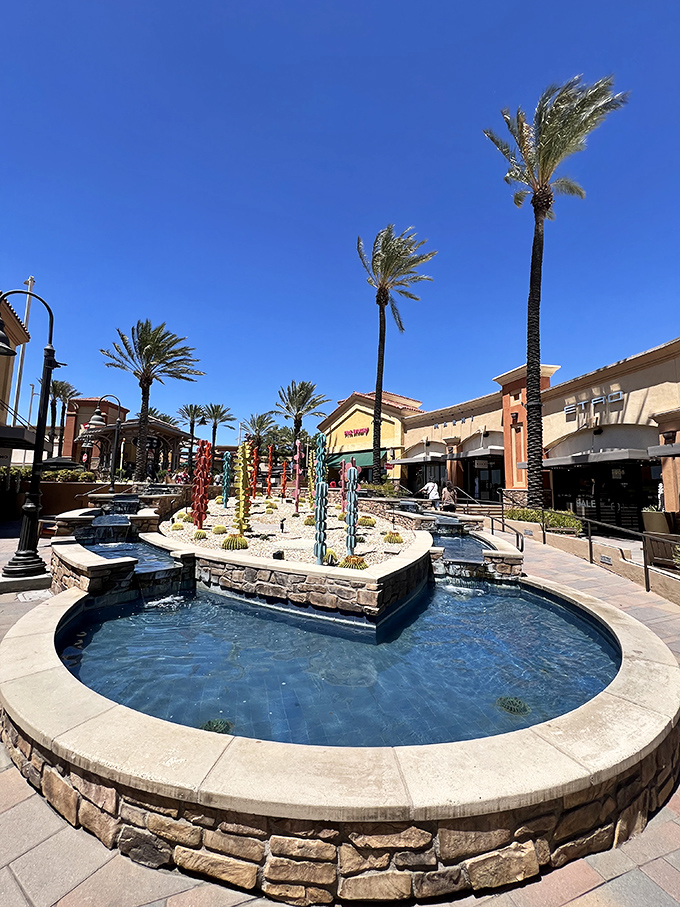 A serene fountain oasis surrounded by desert landscaping offers shoppers a moment of Zen before diving back into the retail marathon.