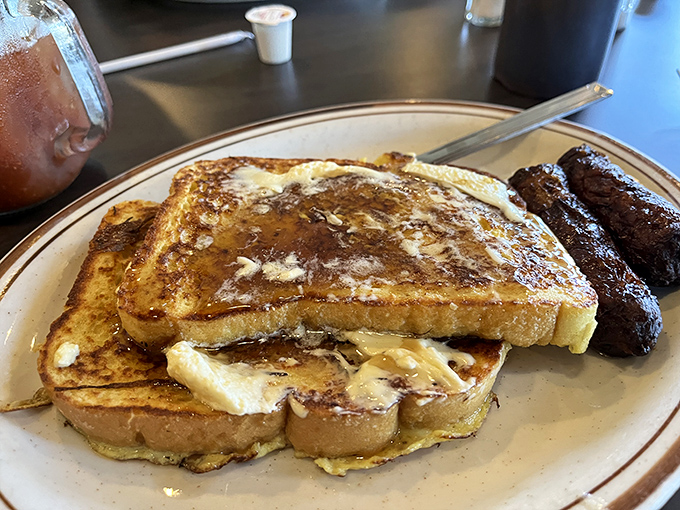 French toast so perfectly golden-brown it belongs in a museum, paired with sausage links that make a compelling argument against plant-based alternatives. 