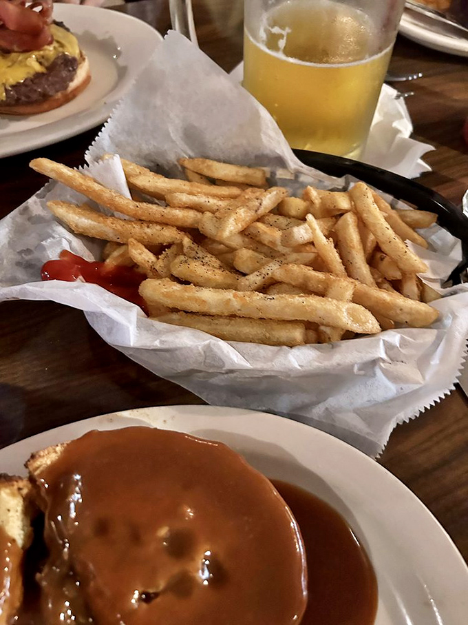 Sometimes the simplest pleasures are the best – like these perfectly golden fries alongside what appears to be gravy-smothered comfort on a plate.