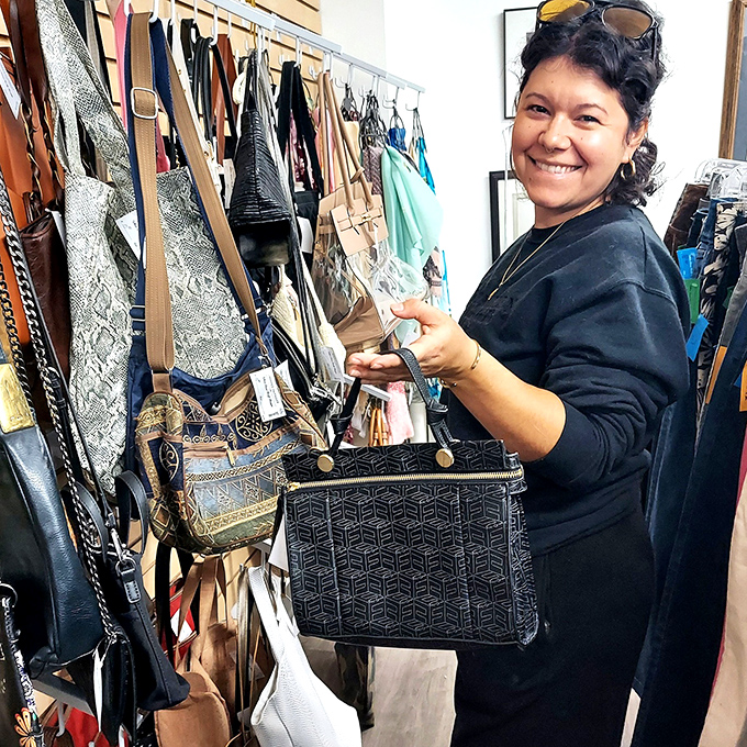 Handbag heaven awaits the savvy shopper. This smiling treasure hunter demonstrates why patience pays off when searching for that perfect pre-loved accessory.