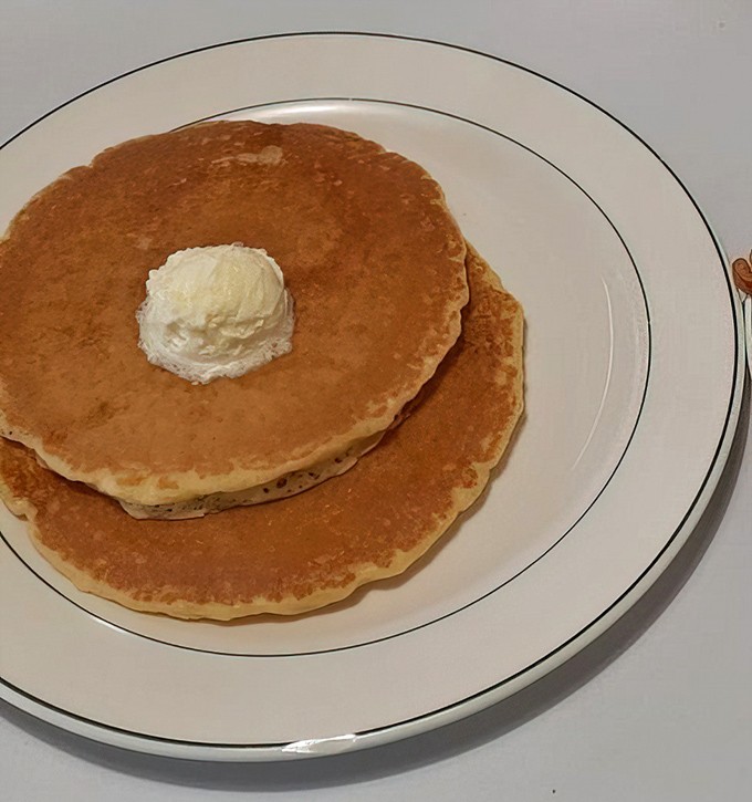 Pancakes so perfectly golden they belong in Fort Knox, with that butter slowly melting into a pool of possibility.