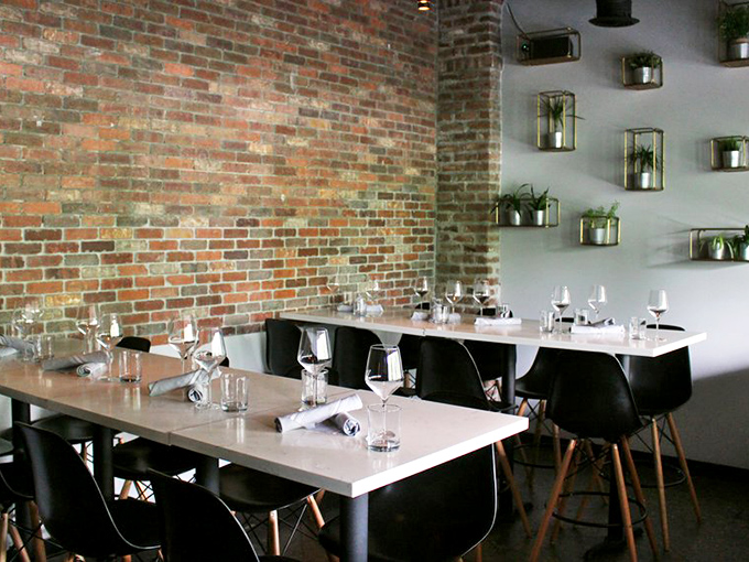 Exposed brick meets sleek modern furnishings in this dining area where every table feels like the best seat in the house.