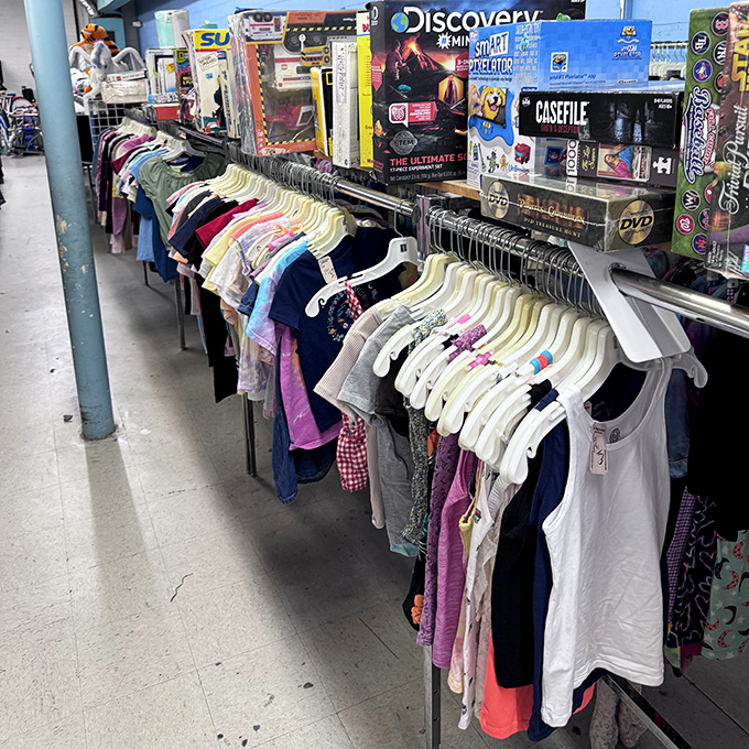 Children's clothing racks flanked by board games and DVDs&mdash;the perfect reminder that kids outgrow everything except your credit card bills.