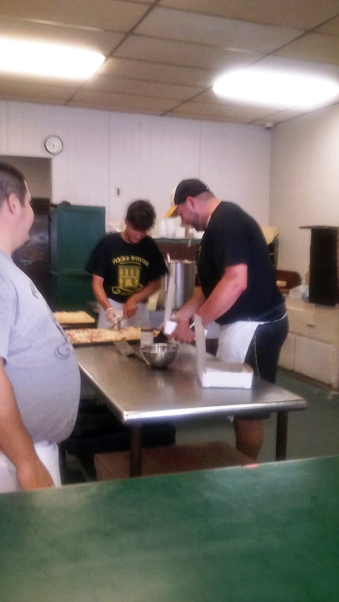 The kitchen choreography is mesmerizing &ndash; like watching a well-rehearsed dance where every movement results in rectangular pizza perfection.