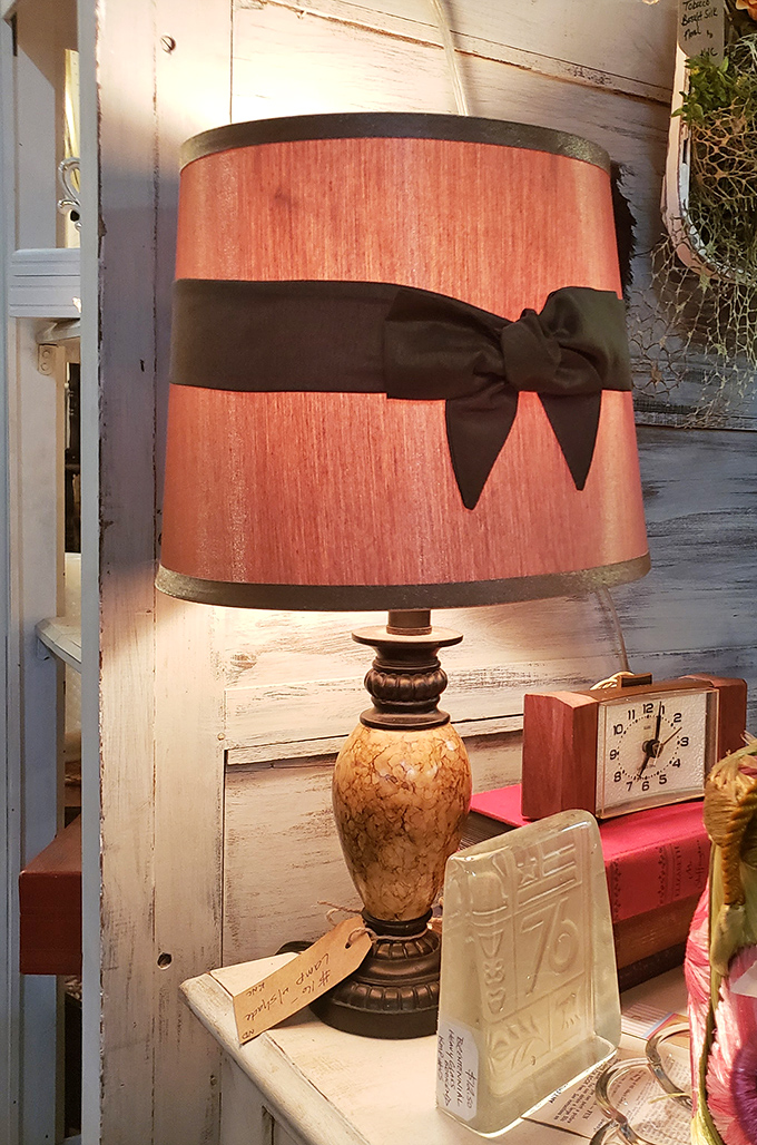 This vintage lamp with its salmon-colored shade and black bow isn't just lighting – it's conversation-starting decor that puts modern knockoffs to shame.
