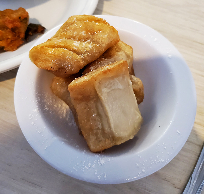 Mini fried apple pies that crackle with each bite, revealing a warm cinnamon-spiced center. Dessert perfection that fits in the palm of your hand.