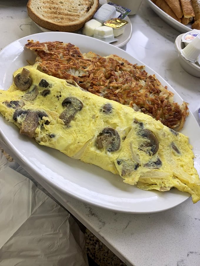 An omelet that's practically a pillow of egg perfection, stuffed with mushrooms and paired with hash browns that deserve their own fan club.