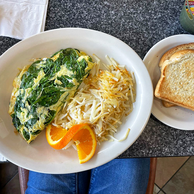 A spinach omelet that Popeye would approve of, paired with hash browns crisped to that perfect shade of "just one more bite."