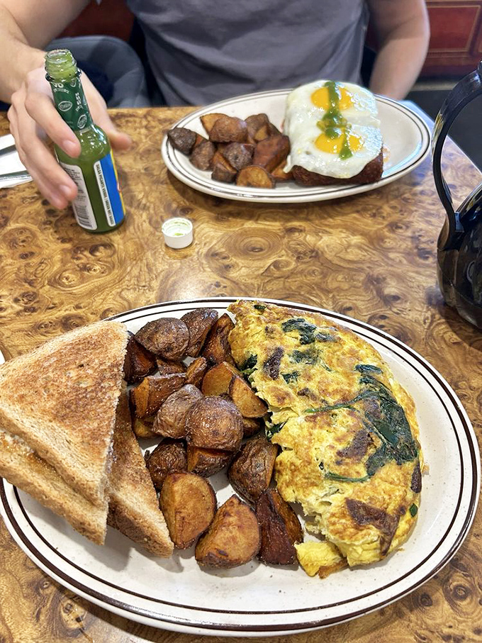 An omelet platter that answers the eternal question: "Why choose between breakfast foods when you can have them all?" Those home fries deserve their own fan club.