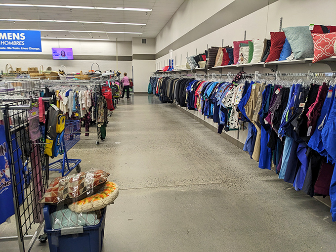 Decorative pillows and home goods perch above clothing racks&mdash;domestic treasures hiding in plain sight.
