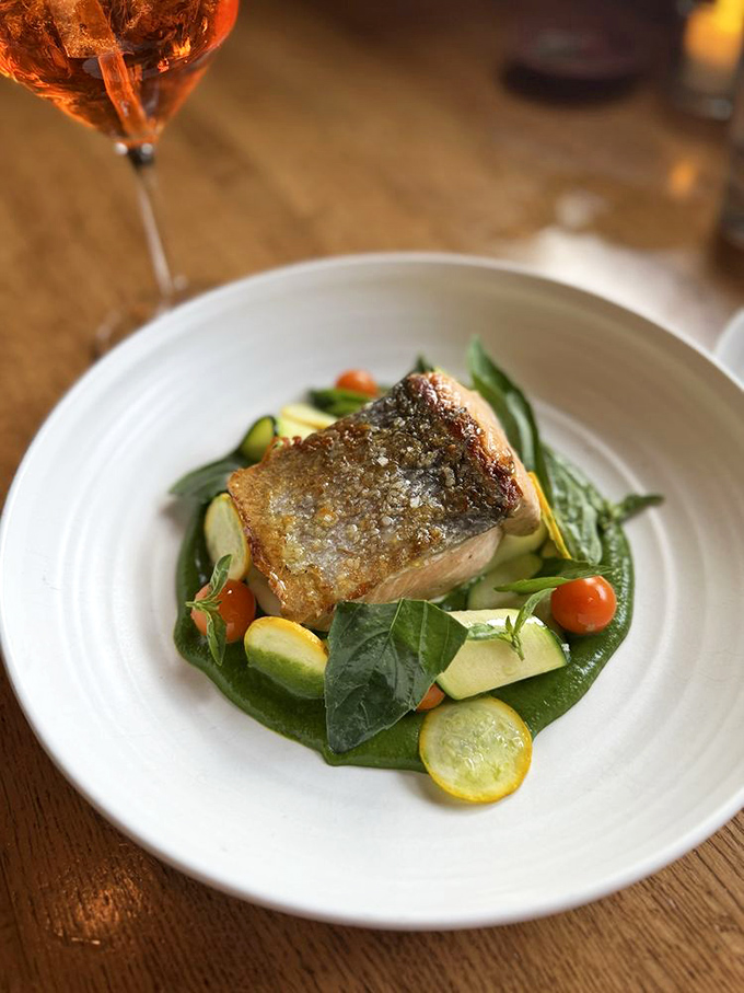 A perfectly seared fish fillet resting on vibrant vegetables – proof that sometimes the simplest preparations showcase seafood's true brilliance.