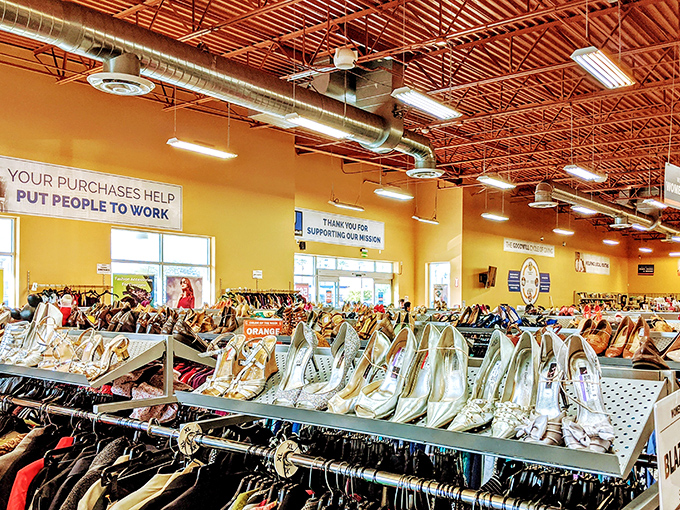 Rows of shoes organized by color because even thrift stores understand the importance of a pleasing visual shopping experience.