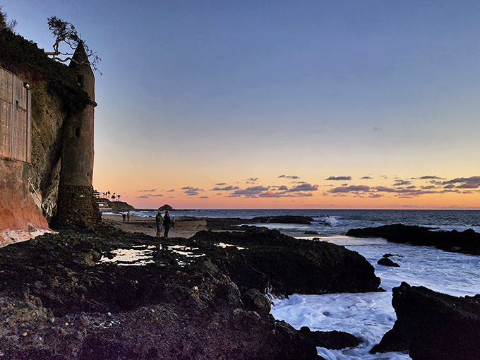Sunset transforms the rocky shoreline into nature's amphitheater, with the tower playing the stoic leading role.